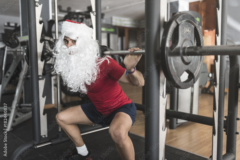 Young boy performs squats on legs training with Santa Claus costume ...