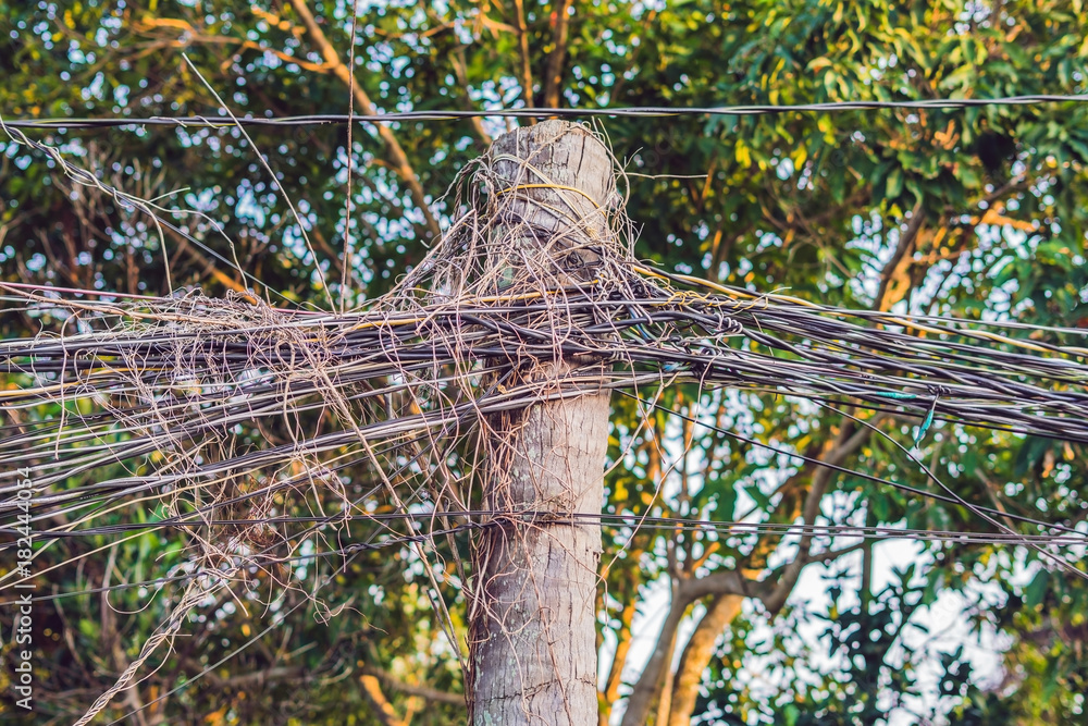 Messy wires attached to the electric pole, the chaos of cables and ...