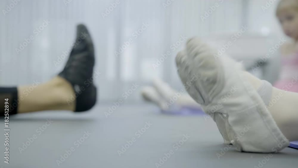 The prima ballerina teaches two girls how to point toes in the class ...