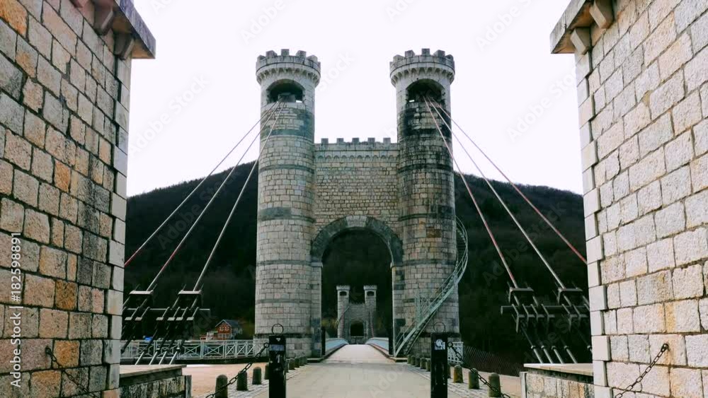 Ancient arched bridge with brick columns and metal cables.Wide stone ...