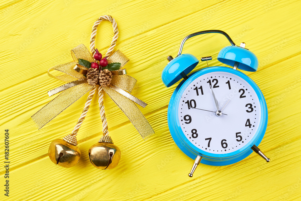 Foto Stock Golden bow with jingle-bell and alarm clock. Two Christmas ...
