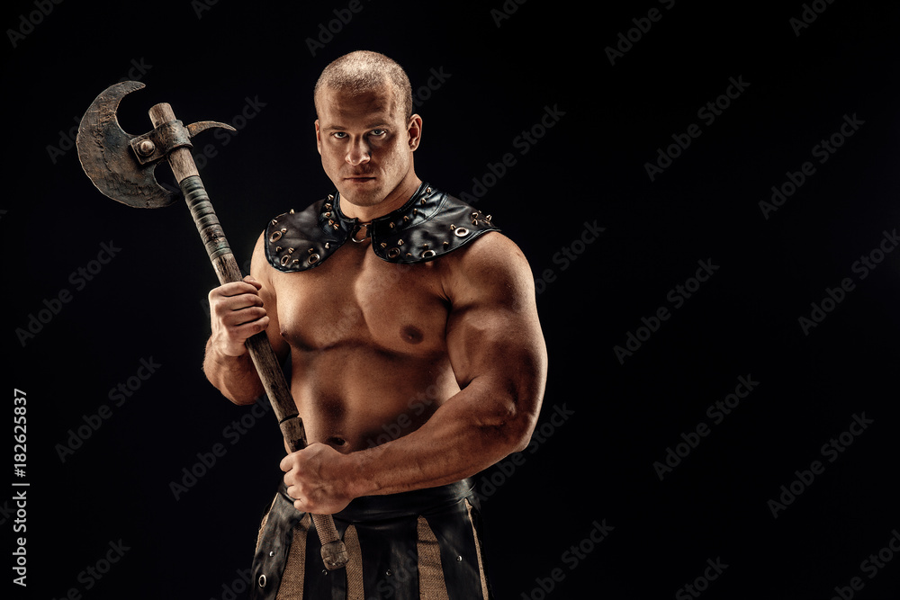 Severe barbarian in leather costume with axe. Studio shot. Black ...