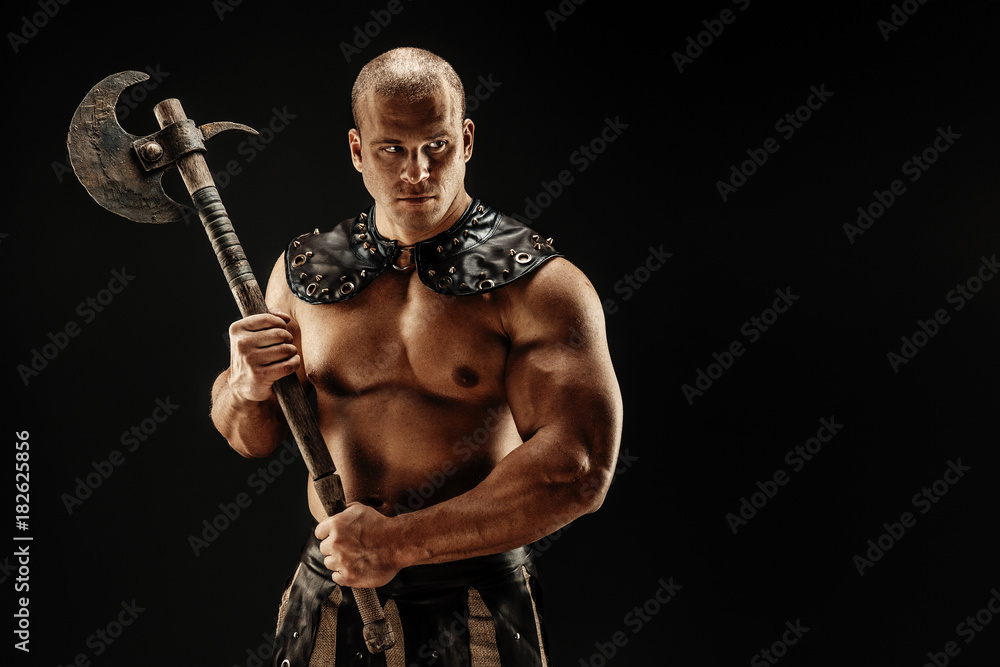 Severe barbarian in leather costume with axe. Studio shot. Black ...
