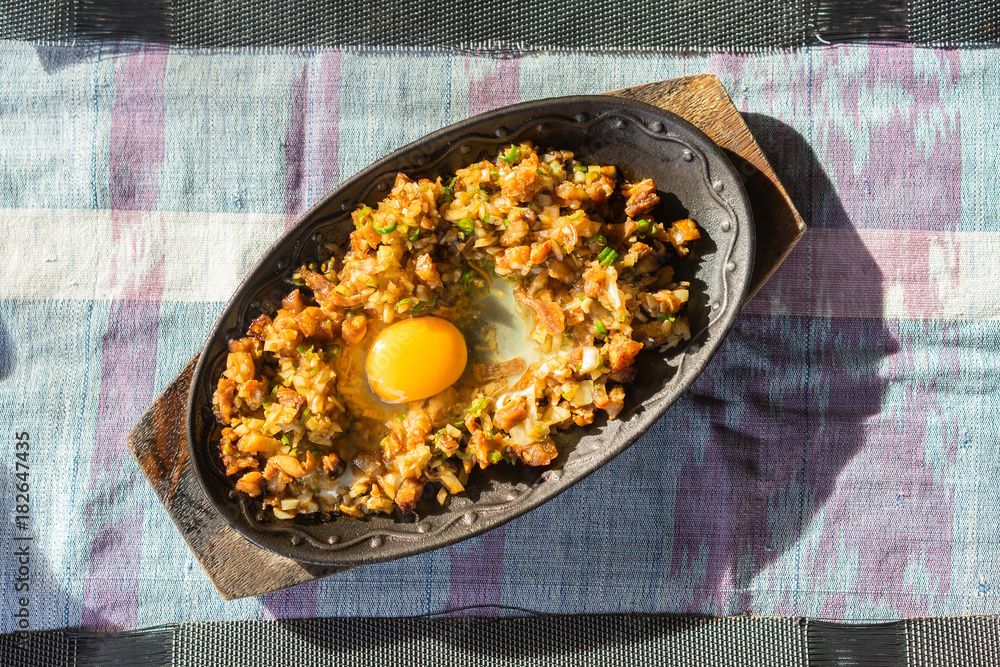 Sizzling pork sisig on the table, filipino cuisine. Overhead view ...