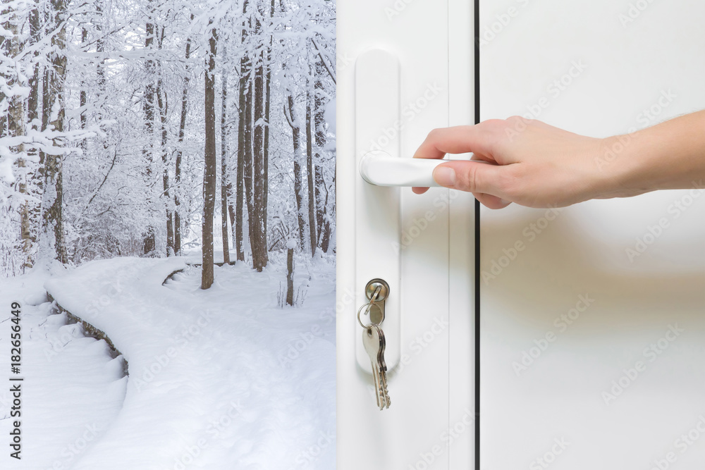 Welcome winter. Woman's hand at home opening the white plastic door ...