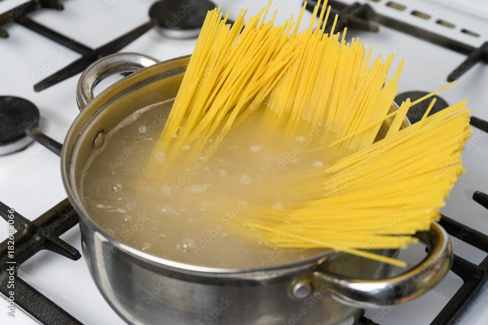 Spaghetti cooked in boiling water on a gas stove. The traditional ...