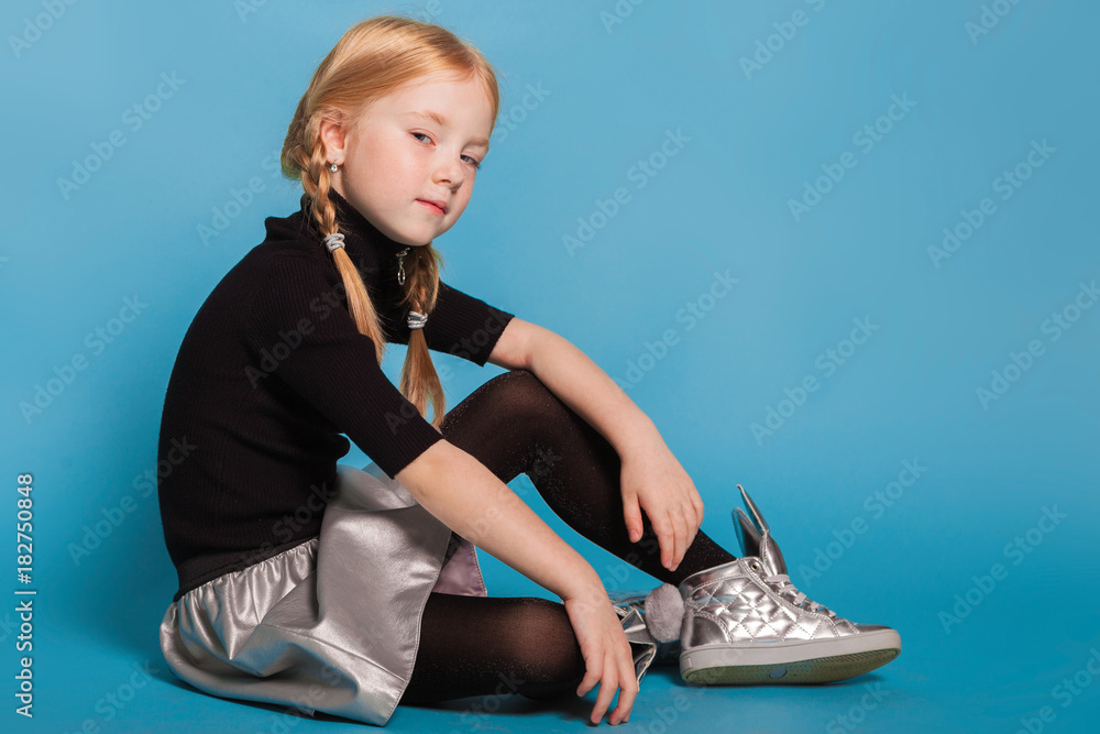 little girl with braids in stylish clothes on blue background Stock ...