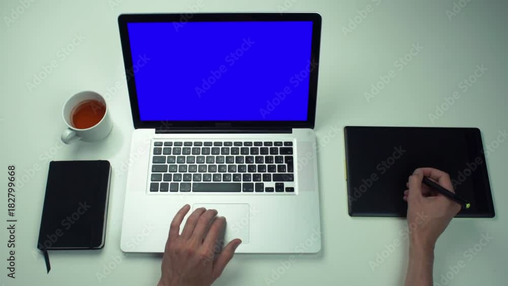 Top view male hands using graphic tab and laptop with green screen at ...