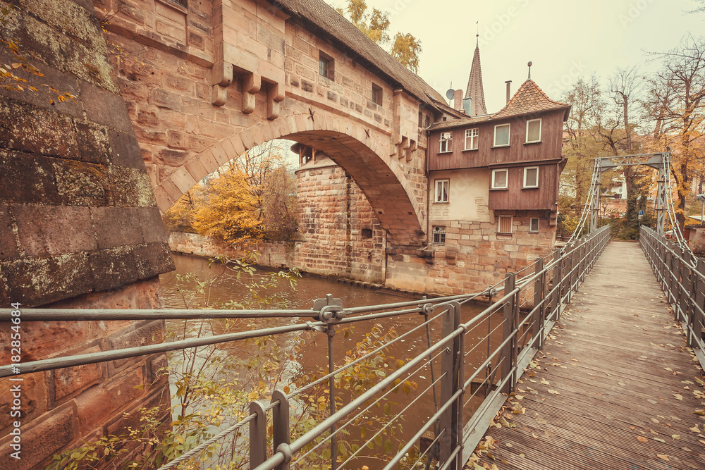 Stone houses and suspension bridge across the river in the historic ...