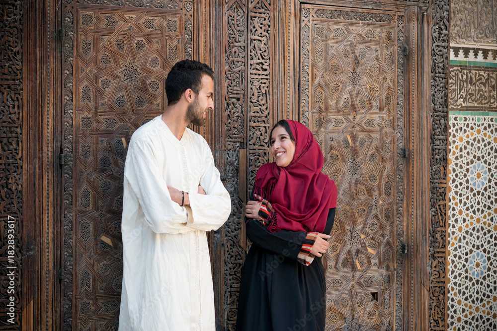 Arab couple in relationship talking and smiling in traditional clothing ...