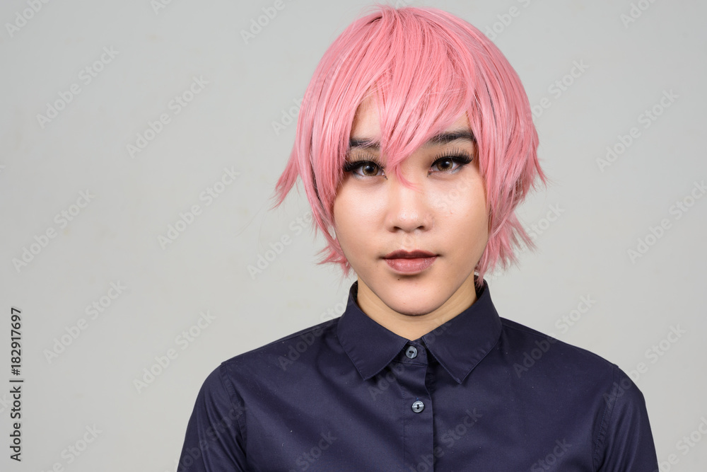 Portrait of androgynous young teenager transgender person wearing pink ...