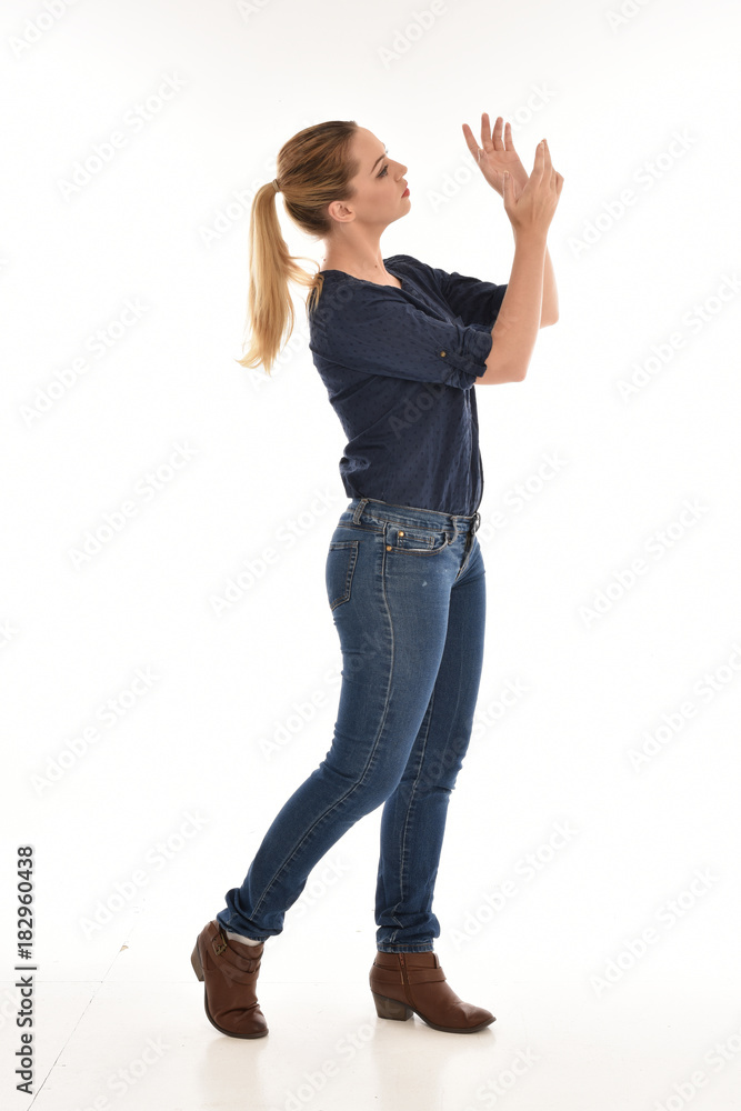 Full length portrait of a girl wearing simple blue shirt and jeans ...