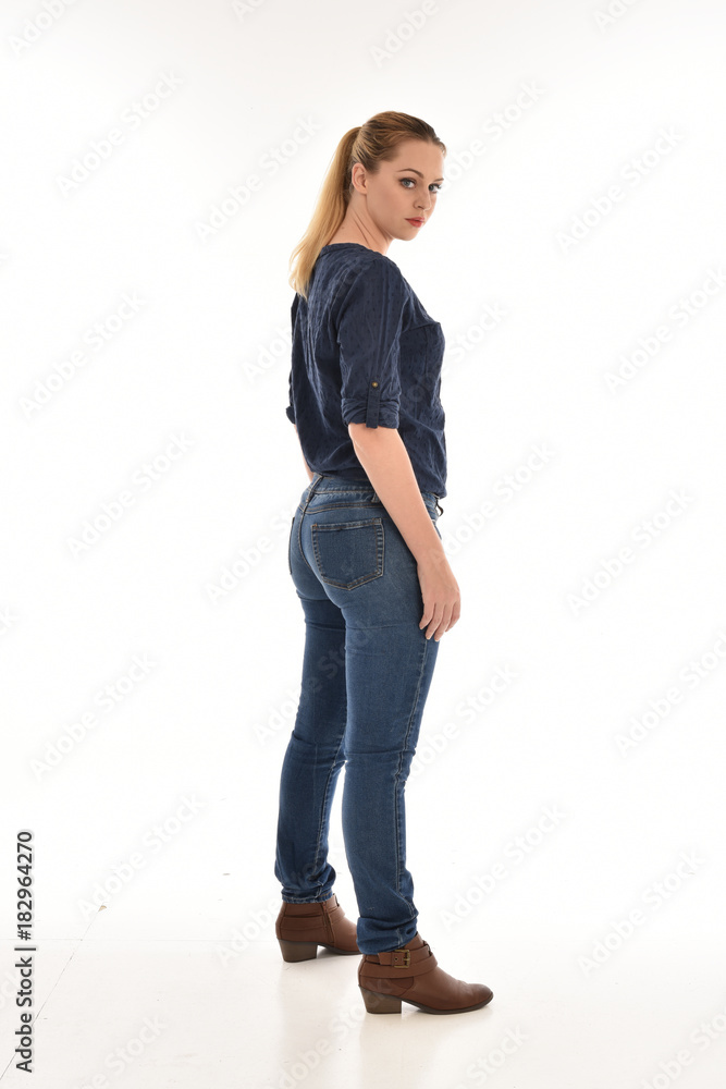 Full length portrait of a girl wearing simple blue shirt and jeans ...