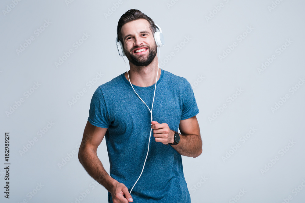 Do a little dance. Handsome young man listening to music in headphones ...