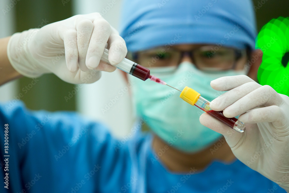 Foto de The doctor with a syringe of blood sample and a rack with other ...