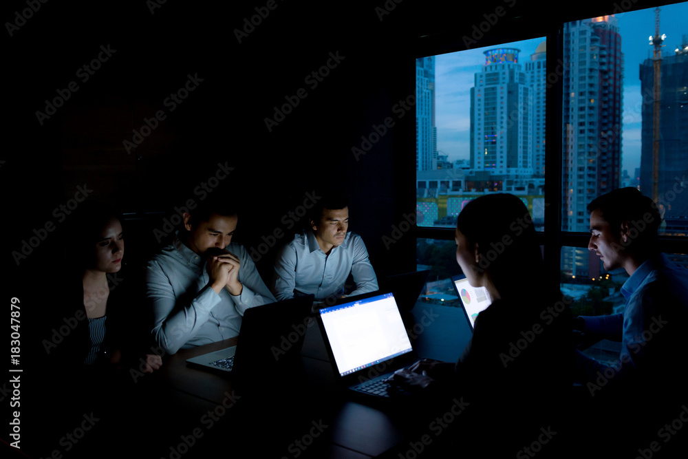 Working overtime concept. Group of young business team working late at ... Working overtime concept. Group of young business team working late at ...