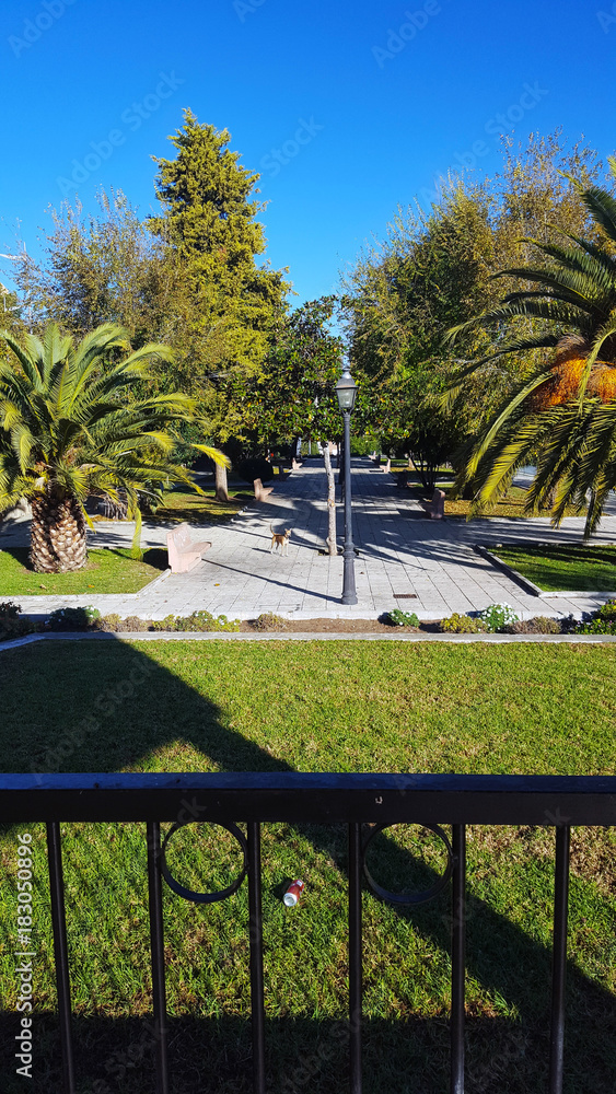 large bandstand in a well tended park with grass and trees in evening ...
