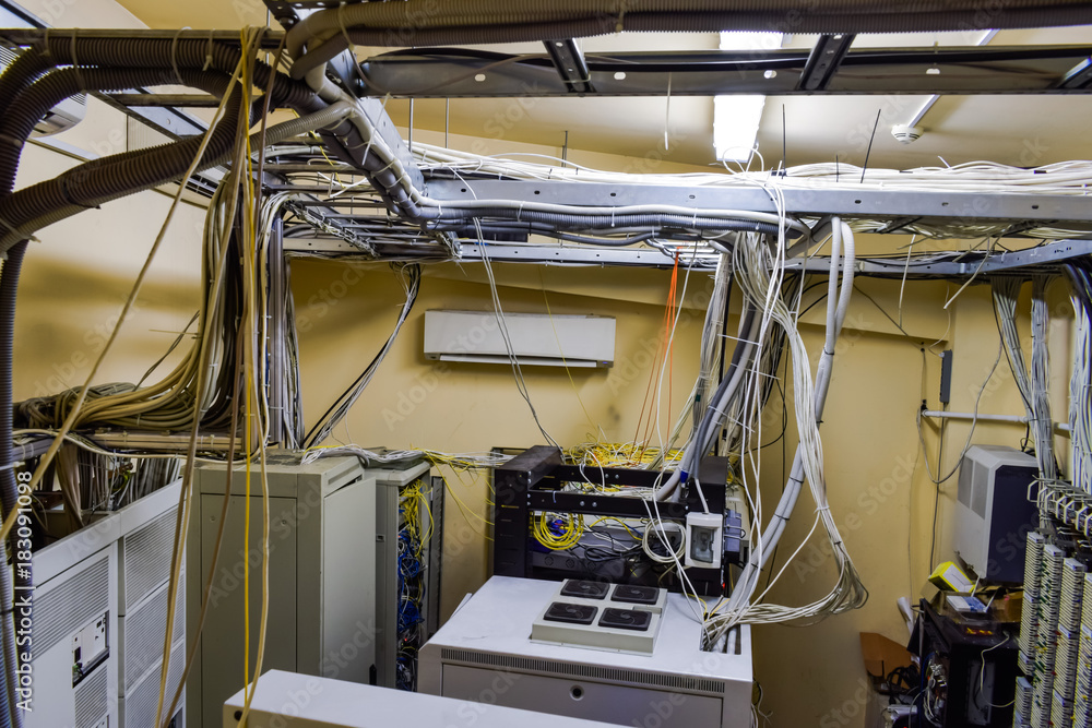 A set of wires and cables intertwined in datacenter server room. Top ...