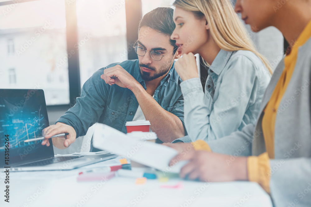 Crew of financial managers discuss solutions, look at graphics on ...