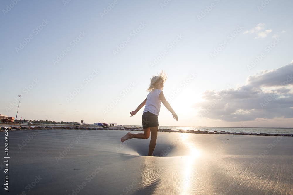 Foto de little girl jump and having good time on trampoline in summer ...