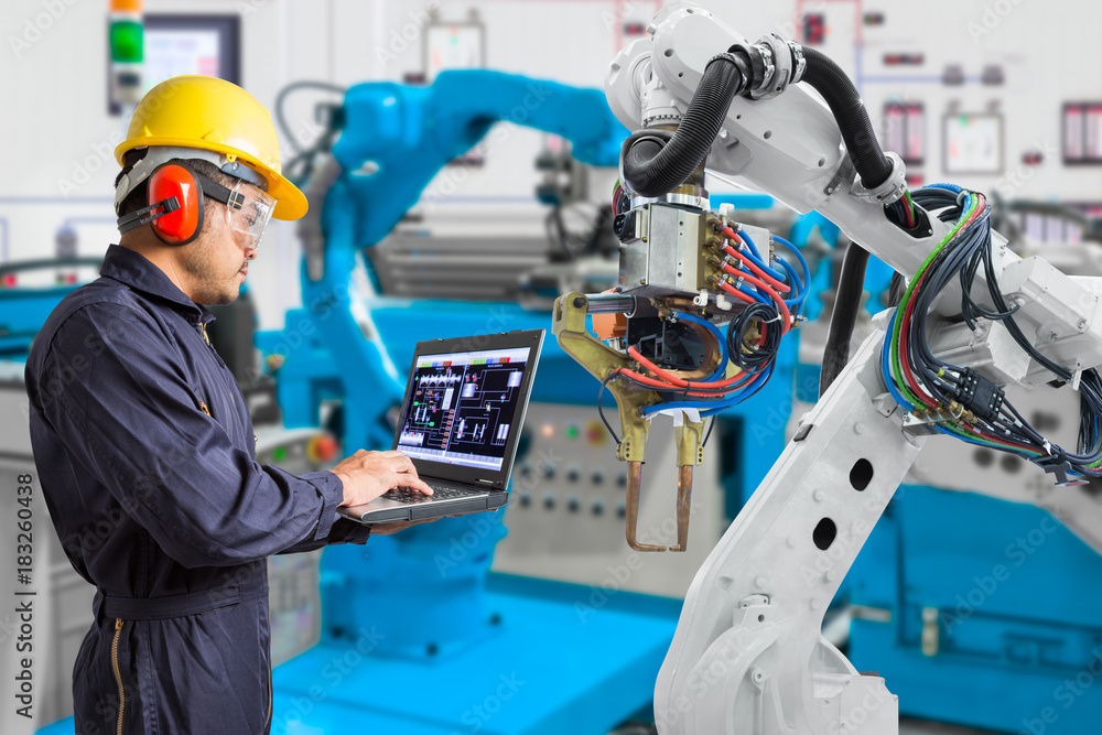 Engineer using laptop computer maintenance automatic robotic hand ...