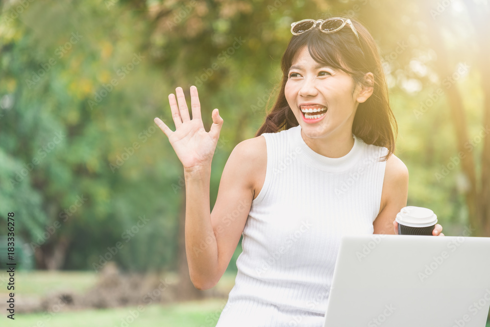 Beautiful Asian woman say hi/hello/greeting friend during working with ...