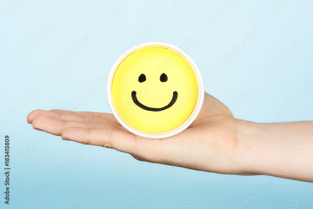 Hand giving hapiness concept. Yellow happy face emoticon. Stock Photo ...