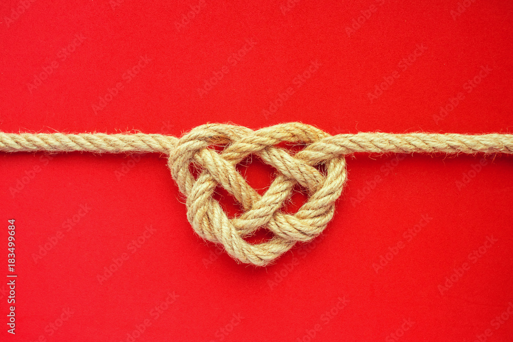Heart shape rope knot on red background. Jute rope celtic knot. Love ...