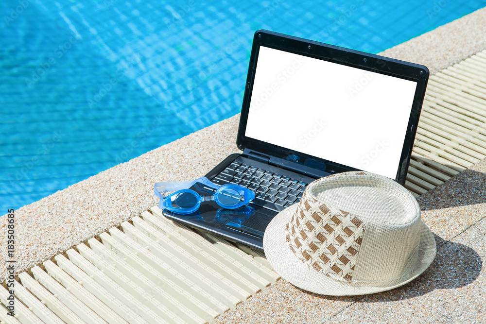 laptop or notebook Swimming goggles and hat at the pool with blank ...