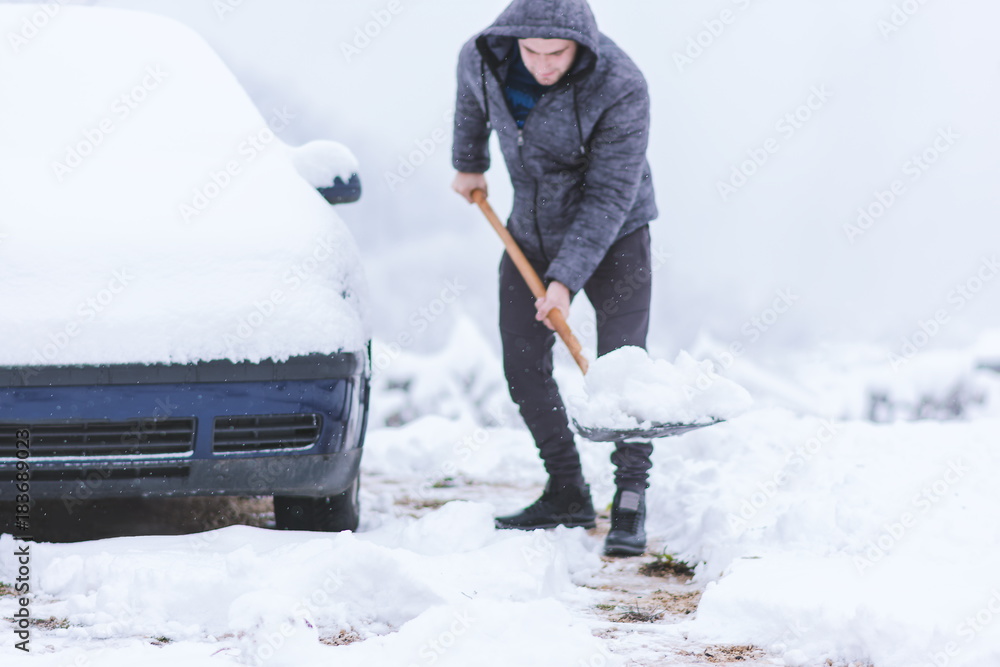Man dressed in jacket cleaning snow around his car. Stock Photo | Adobe ...