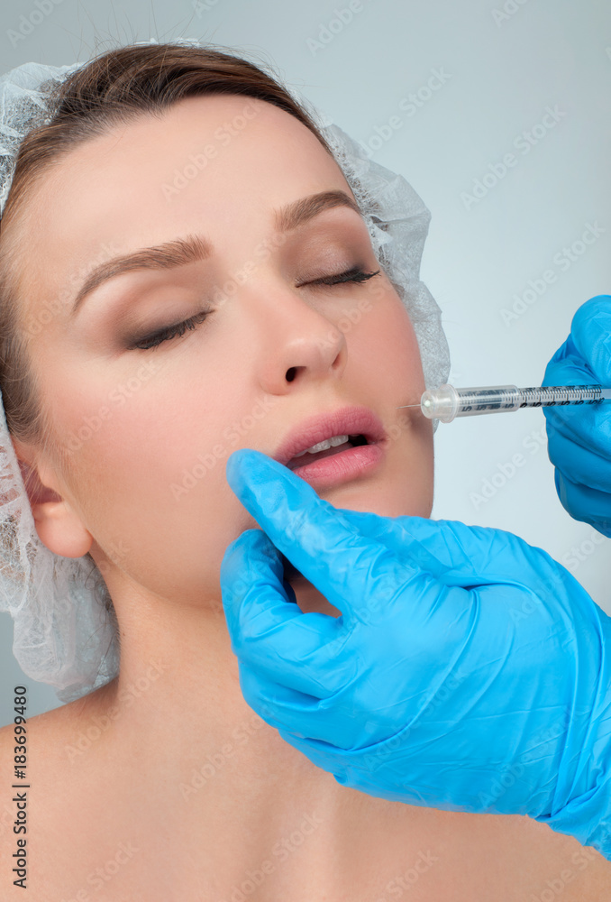 Beautiful girl receiving filler injection in lips. Plastic Surgery ...