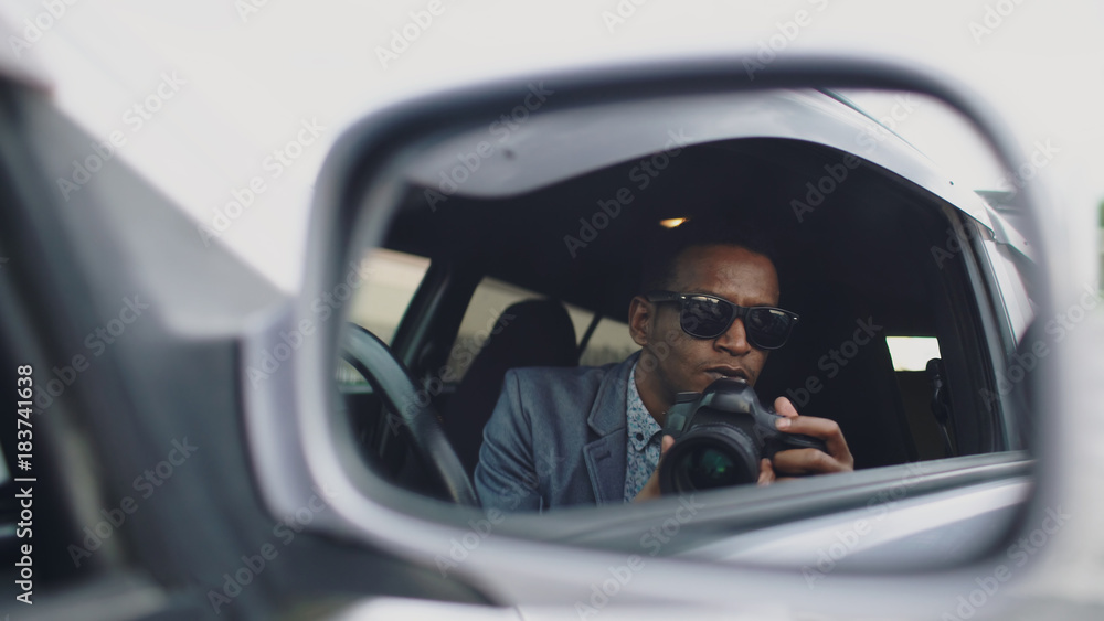 Foto de Reflection in side mirror of police man sitting inside car and ...