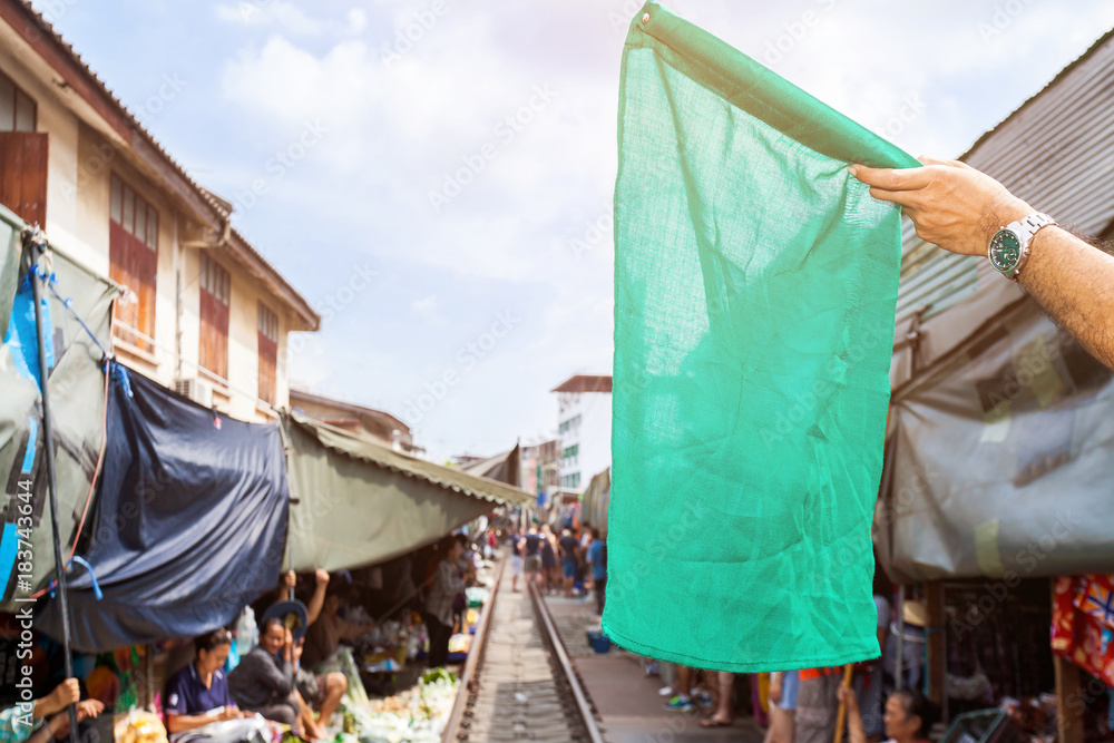 Safety signal : Green flag gives a signal : Railway officials hold the ...