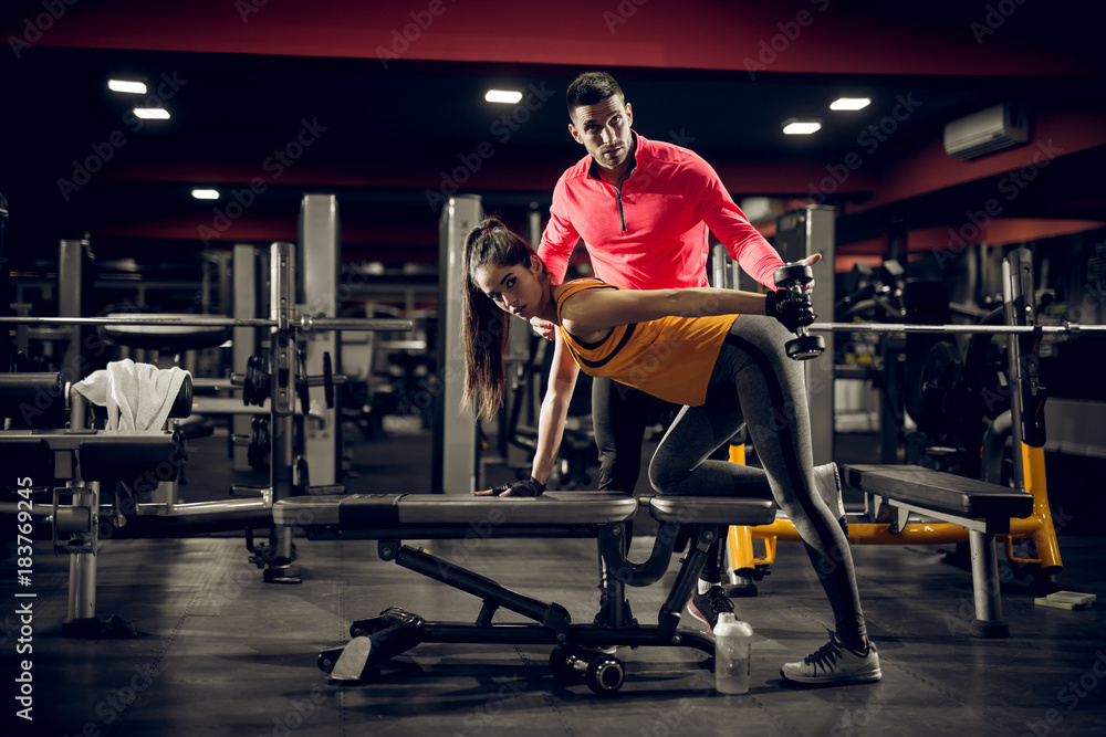 Focused motivated young slim happy fitness woman crouch on the bench ...