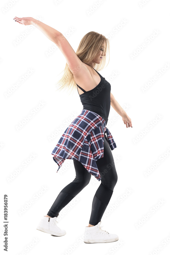 Side view of dance hall female dancer moving with spread arms while ...