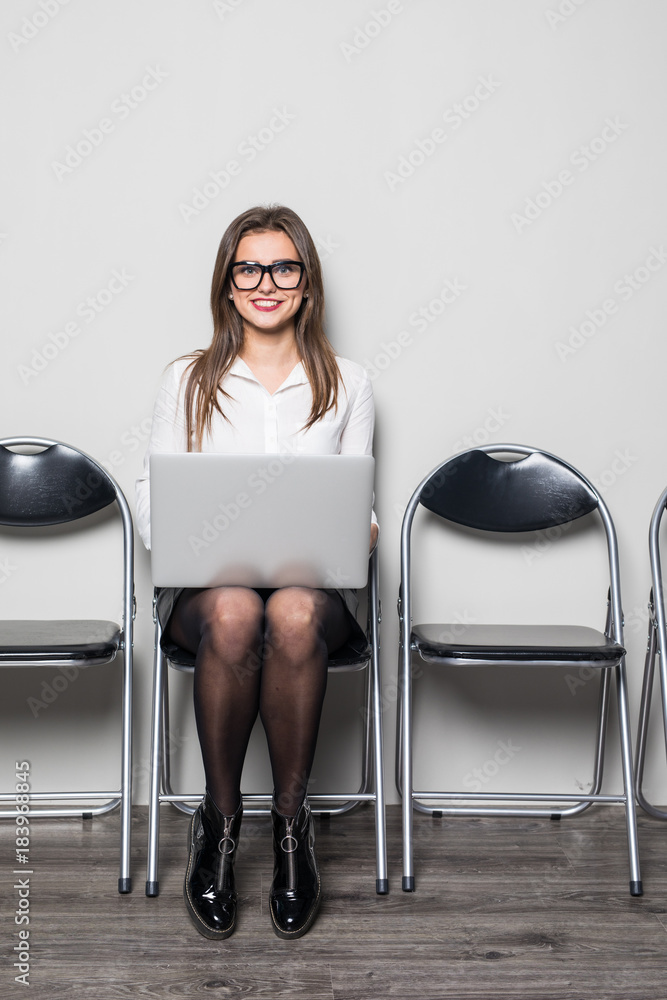 Young smiling office worker woman sitting on wood floor chair using ...