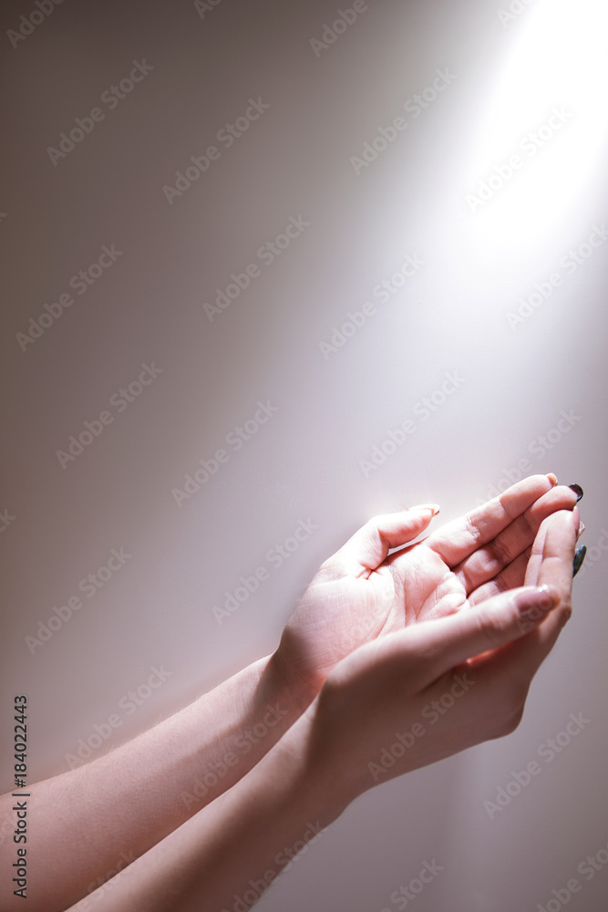 Hands under the glowing light ready to recieve Grace of God. Fervent ...
