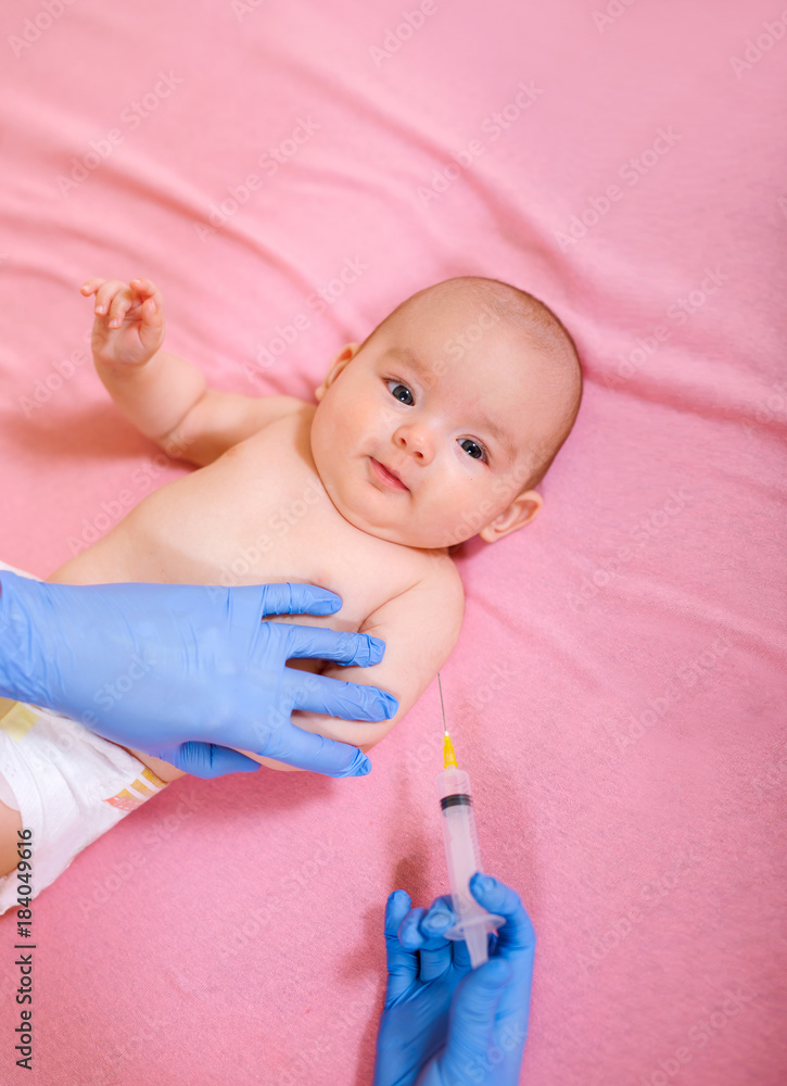 Baby receiving vaccine. Pediatrician giving a baby girl intramuscular ...