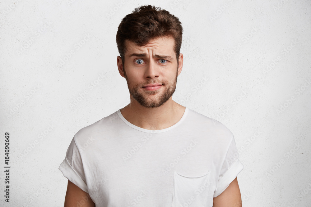 Indignant puzzled male model with attractive appearance frowns face in ...
