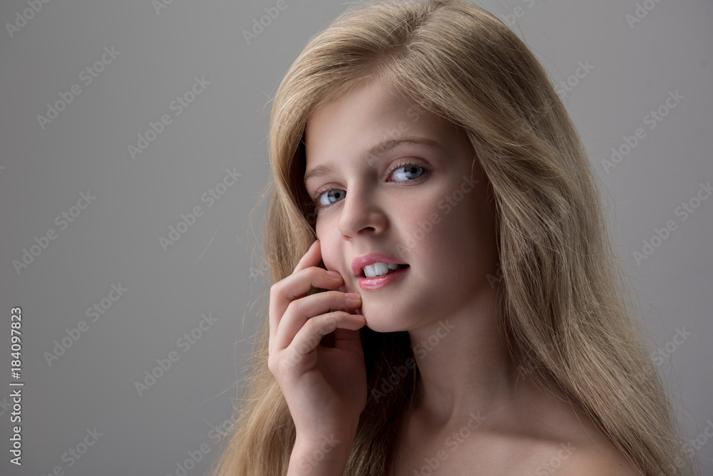 My flawless skin. Joyful little girl is standing and looking at camera ...