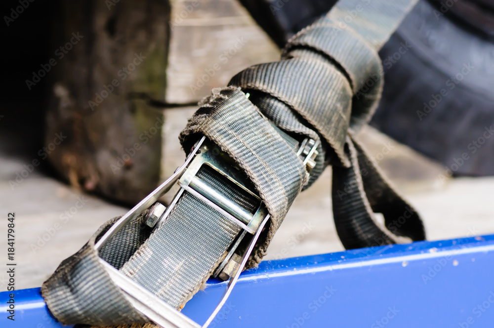 Foto de Webbing and ratchet lashing tie-down strap on a flatbed lorry ...