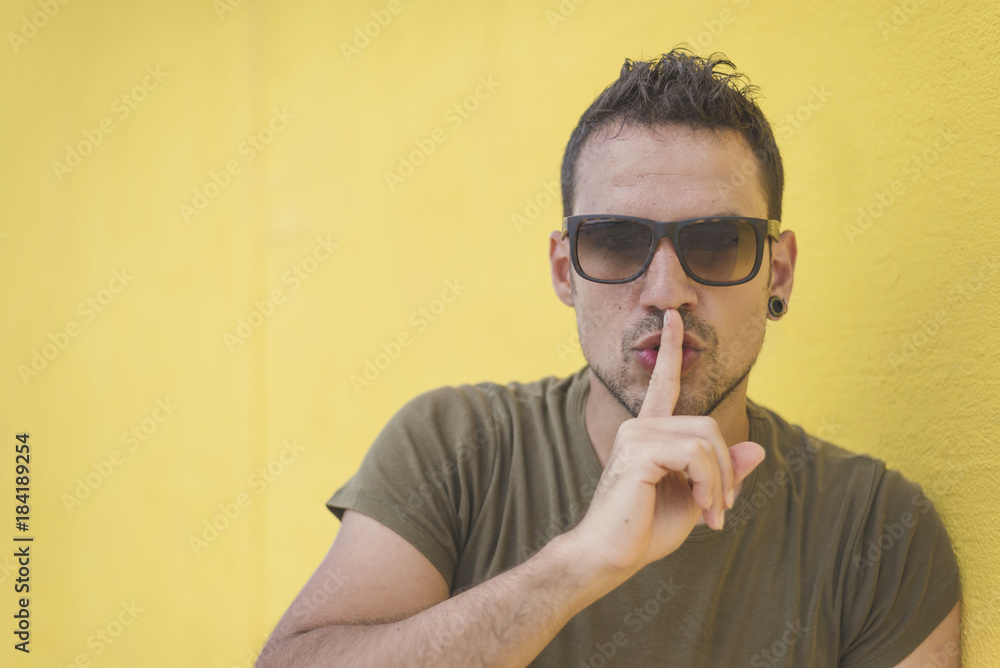 Close up shot of handsome male with shhh gesture Stock Photo | Adobe Stock