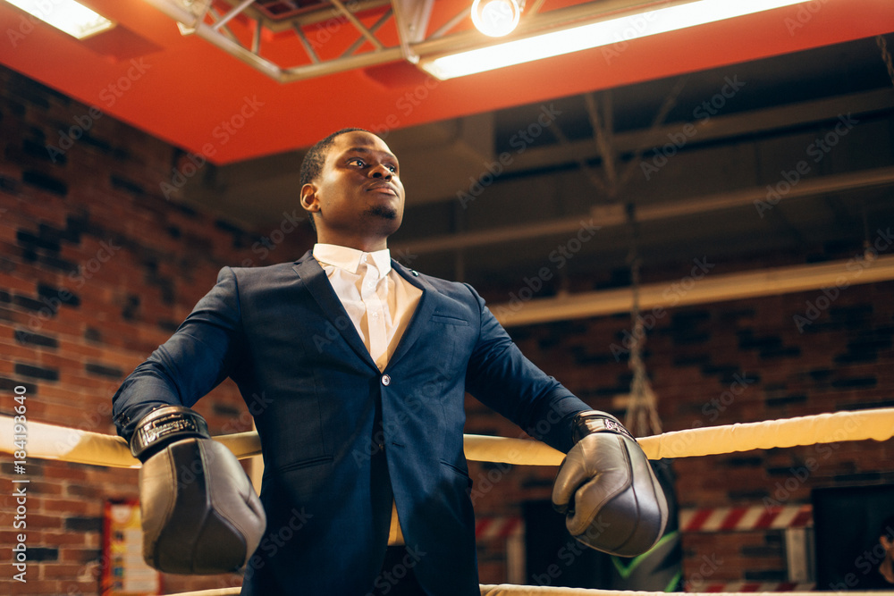 Stock image of person wearing business suit and boxing gloves. African ...