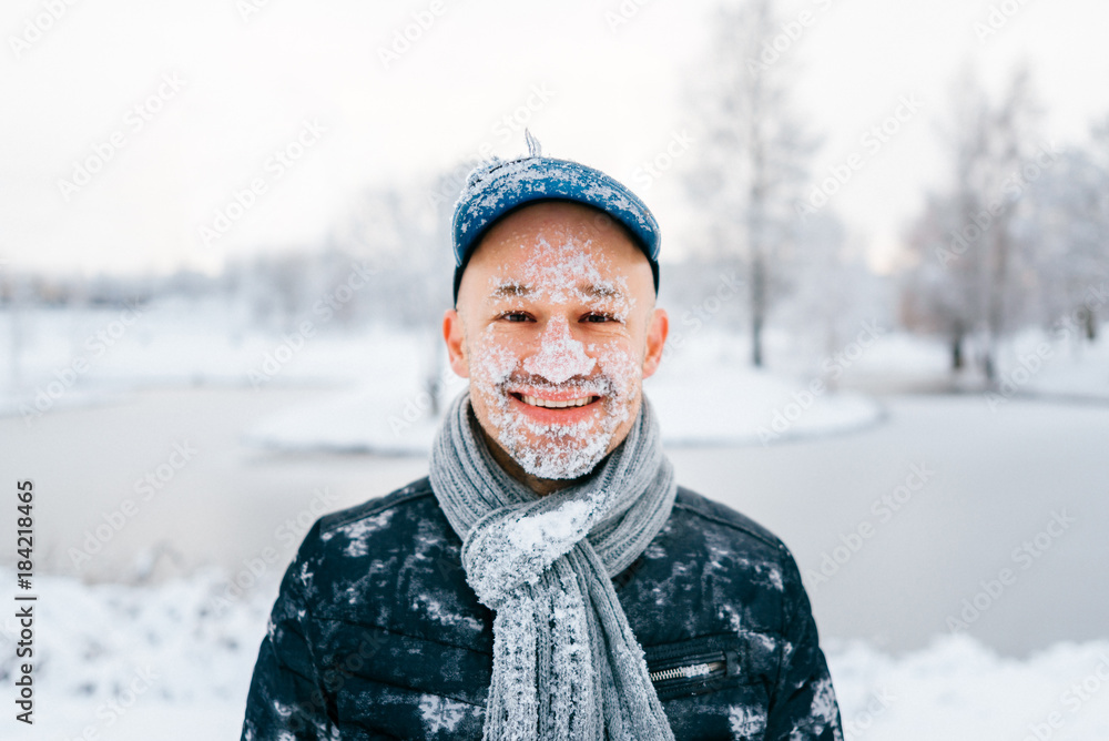 Closeup portrait of male face covered with snow. Crazy cheerful funny ...