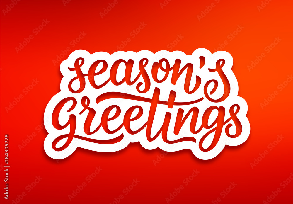 Seasons greetings text on white paper label with carving over red ...