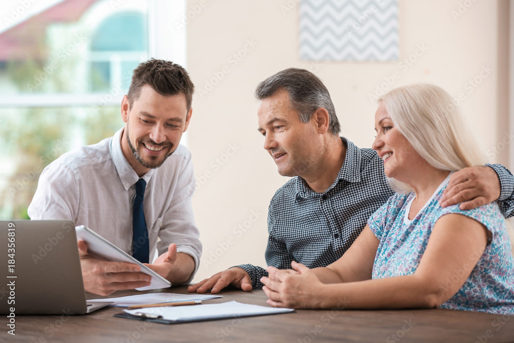 Male insurance agent consulting senior couple in office Stock Photo ...
