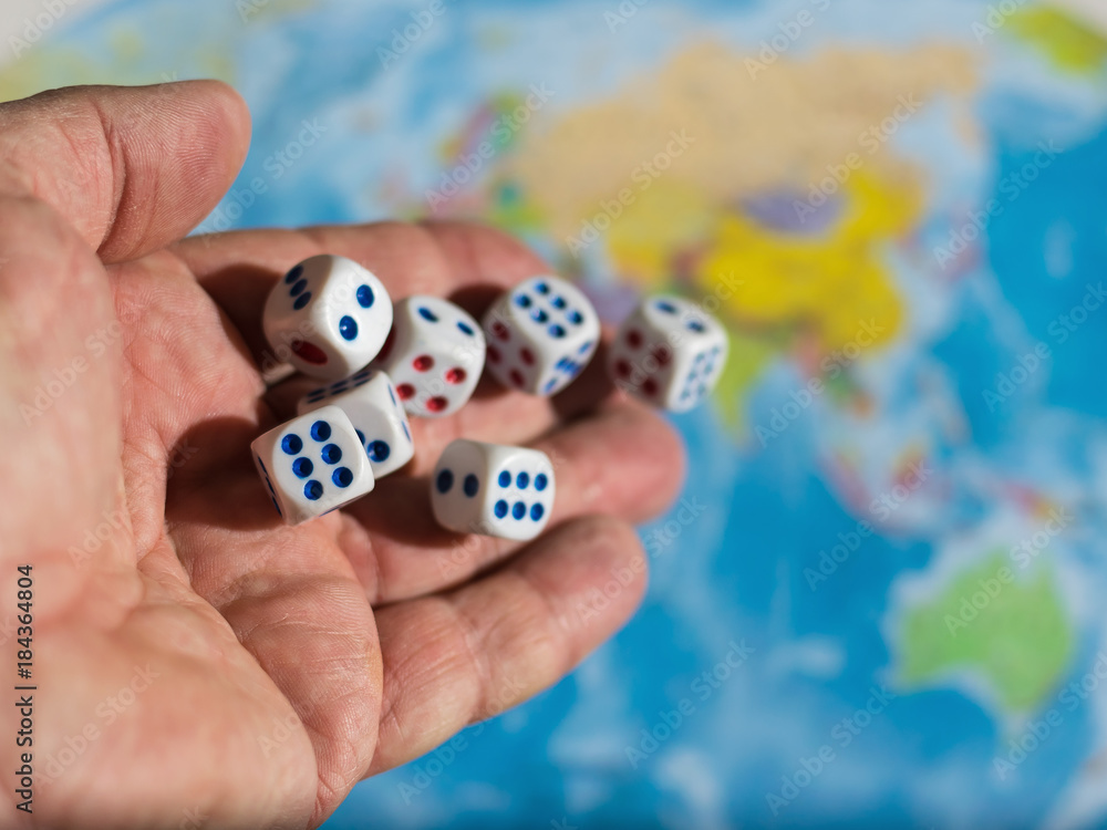 Six dice roll with a man's hands on world map. World order.d map and ...