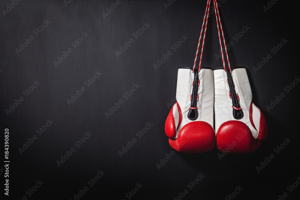 Professional red boxing gloves hanging on black background with copy ...