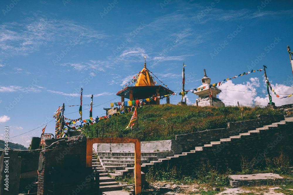 traditional architecture and colorful prayer flags in Indian Himalayas ...