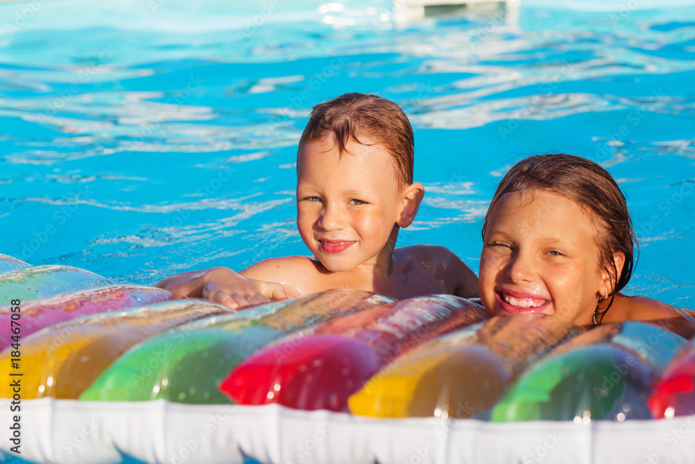 Little children playing and having fun in swimming pool with air ...